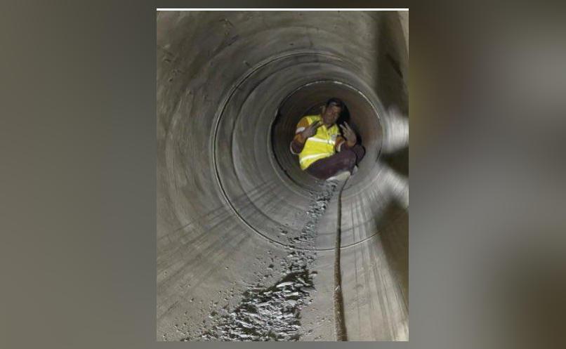 Trapped worker shows victory sign from pipe while being rescued from ...